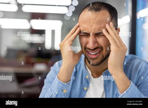 A Close Up Photo Of A Muslim Young Man Sitting In The Office Behind The