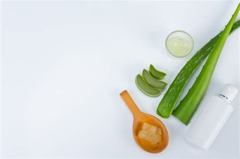 알로에 베라 신선한 조각과 나무로되는 숟가락에 젤과 나뭇잎 알로에 베라는 미용에 천연 허브를 사용합니다 무료 사진