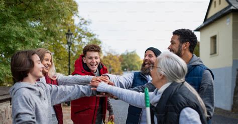 행복한 지역 사회 봉사 자원 봉사자들의 다양한 그룹이 거리에서 손을 모으고 있습니다 사진 Unsplash의 성인 이미지