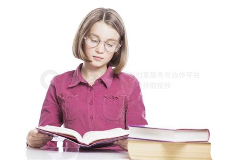 戴眼镜的疲惫女孩坐在桌子旁看书。孤立的白色背景。图片免费下载 5001056276 千图网pro