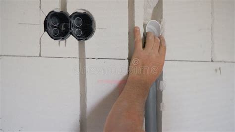 Construction Worker Expanding Electric Cable Chase Grooves With Wall