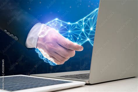 Businessman Shaking Hands With Digital Partner Extending From Laptop