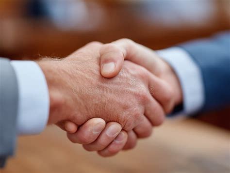 Two Men Shaking Hands In Front Of A Wooden Table Stock Image Image Of