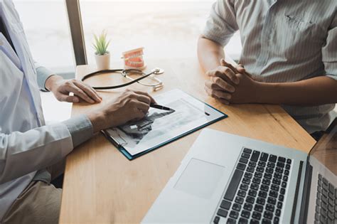 아시아 치과 의사 들은 치아와 미래의 치료 또는 수술의 문제를 설명 하는 펜을 보유 하 고 있습니다 개념에 대한 스톡 사진 및