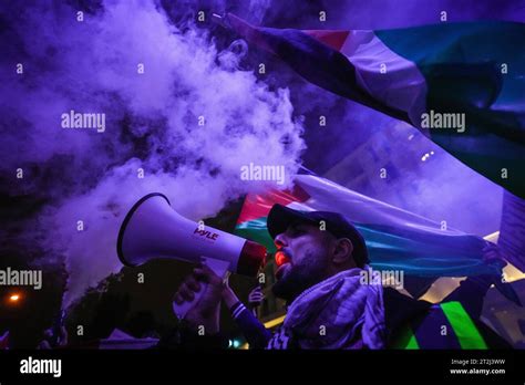 A Man Uses A Bullhorn As Smoke Bombs Are Set Off During A Demonstration