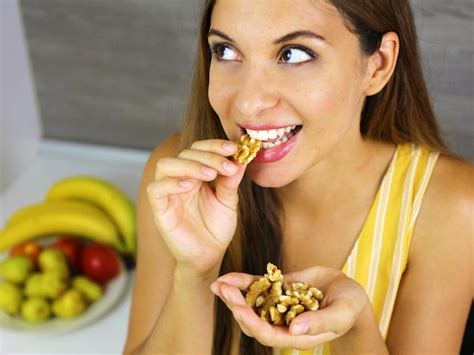 Premium Photo Woman Eating Walnuts At Home
