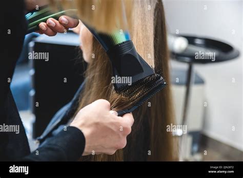 Master Woman Hairdresser Dries The Girls Hair With A Hairdryer And