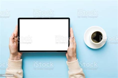 커피 한 잔과 함께 문자 메시지 또는 홍보 콘텐츠 옴 테이블에 대한 빈 복사 공간 화면이 있는 디지털 태블릿을 들고 있는 이미지