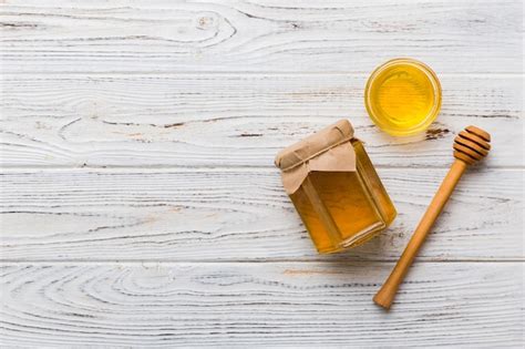 Premium Photo Glass Jar Of Honey With Wooden Drizzler On Colored