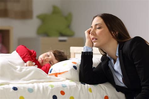 Madre Cansada Del Trabajador Que Duerme Al Lado De Su Hija Foto De