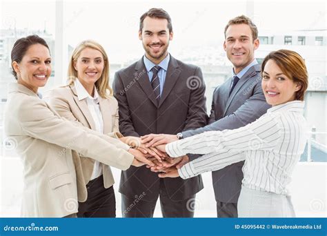 Ejecutivos Felices Que Llevan A Cabo Las Manos Juntas En Oficina Foto