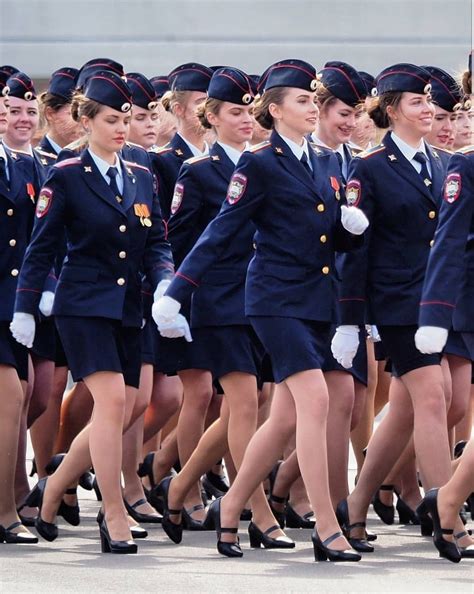 A Group Of Women In Uniform Marching Down The Street