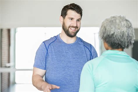 잘생긴 물리 치료사는 시 니 어 성인 여성 고객과 작업 하는 동안 미소 남성에 대한 스톡 사진 및 기타 이미지 남성