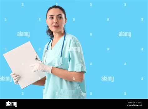 Female Medical Assistant With Folder On Light Blue Background Stock