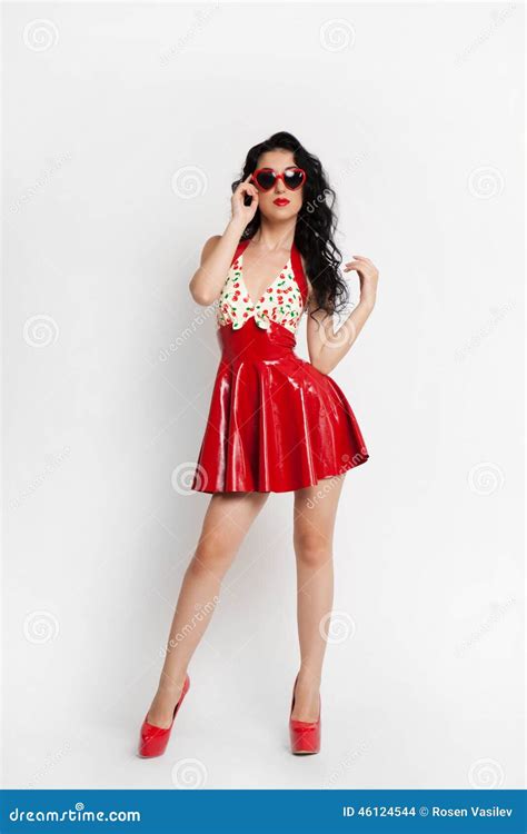 Femme Sexy Dans La Robe Rouge De Latex Avec Des Lunettes De Soleil