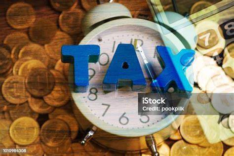 개념은 세금을 지불 하는 시간 동전과 빈티지 알람 시계 사무 용품 사무실 작업 필수 도구 또는 항목의 스택에 세금 알파벳 개념에