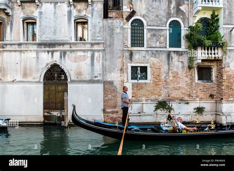 A Gondola Sailing Through The Backstreet Canals Of Venice Italy Stock