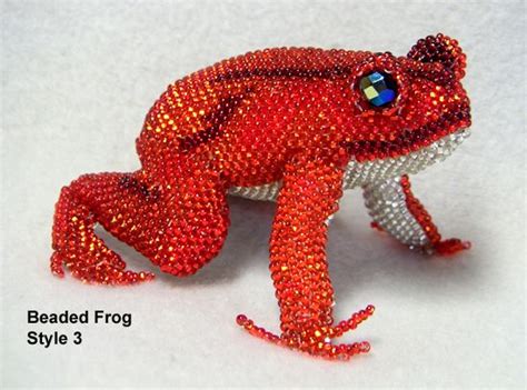 A Beaded Frog Sitting On Top Of A White Surface