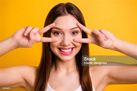 사랑스러운 매력적인 예쁜 여자 젊음의 클로즈업 사진 그녀는 V사인이 여름 휴가 휴가 자유 시간을 입고 흰색 싱글 탑 고립 된 밝은 배경을 가지고 갈색 머리에 대한 스톡 사진