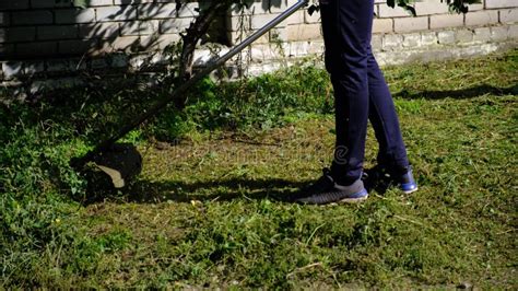 Lawn Mower On Green Grass A Man Cuts A Thick Lawn Garden Care