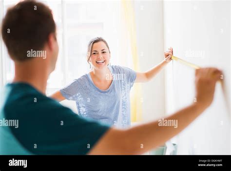 Couple Measuring Wall Stock Photo Alamy