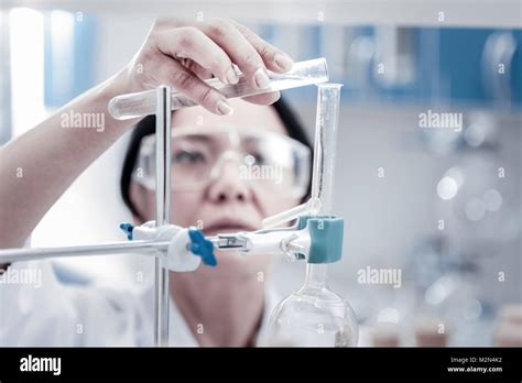 Female Researcher Conducting Chemical Experiment In Laboratory Stock