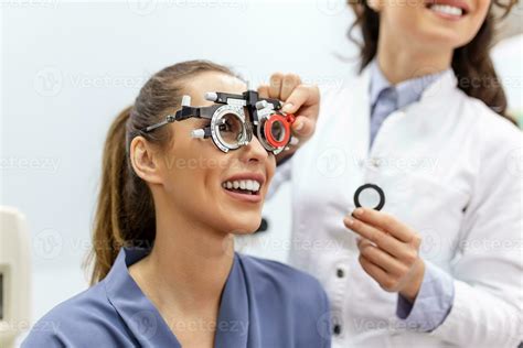 oftalmólogo que examina a la mujer con marco de prueba de optometrista paciente femenina para