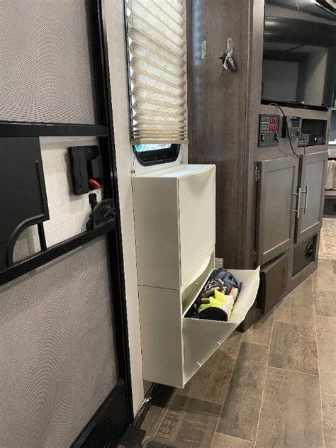 The Inside Of A Travel Trailer With Its Door Open And Storage Compartment On The Side