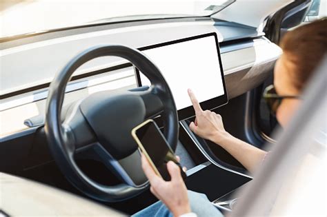 전기 자동차 인테리어 모형 터치 스크린 디스플레이에서 인포테인먼트 시스템에 종사하는 여자 차량용 터치스크린이 있는 스마트폰 연결 Brand Name Smart Phone에