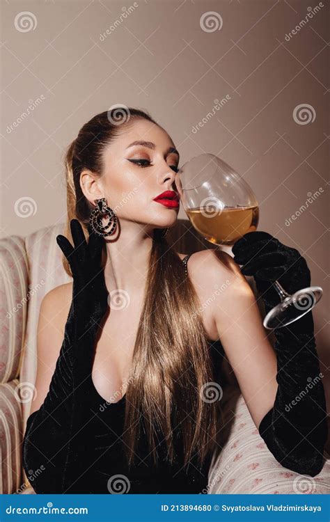 Beautiful Woman With Blond Hair In Elegant Clothes Relaxing With Glass