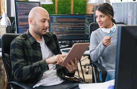 Software Programmers Analyzing Database And Script Ideas On A Tablet