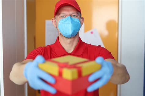 보호 장갑을 끼고 있는 의료용 마스크를 착용한 택배기사가 상자를 가져왔습니다 19에 대한 스톡 사진 및 기타 이미지 19