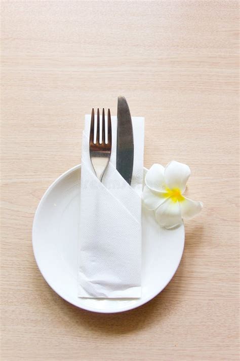 Knife And Fork Wrapped In A Napkin Lying On A White Plate Decorated