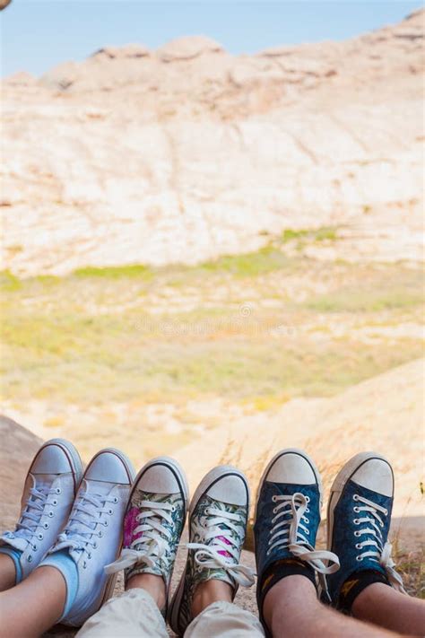 Close Up Of Three Pairs Of Legs In Sneakers On A Background Of