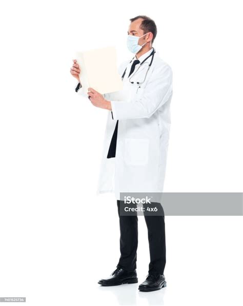 백인 젊은 남성 의사가 실험실 코트를 입고 마닐라 폴더를 들고 흰색 배경 앞에 서있다 남자에 대한 스톡 사진 및 기타 이미지 남자 남자들만 연구실 가운 Istock