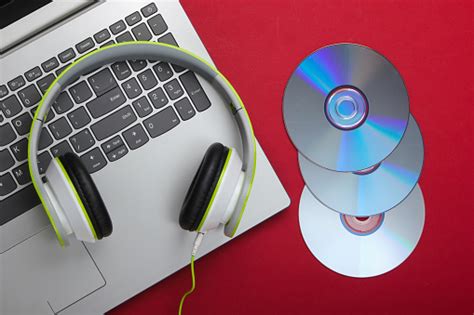 헤드폰 빨간색 배경에 Cd 디스크가있는 노트북 게임 엔터테인먼트 또는 레저 컨셉 맨 위 보기입니다 플랫 레이 개념에 대한 스톡