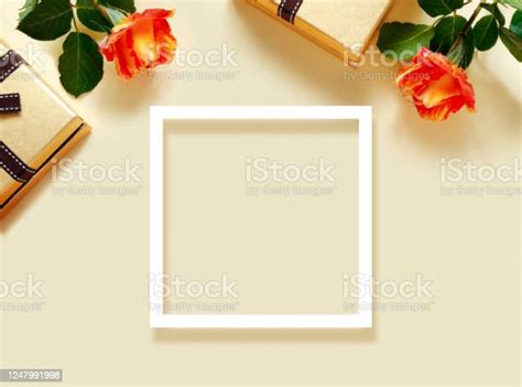 아름다운 노란색 장미와 황금 선물 상자와 섬세한 노란색 종이 배경에 흰색 프레임 결혼식을위한 인사말 카드 텍스트에 대한 장소