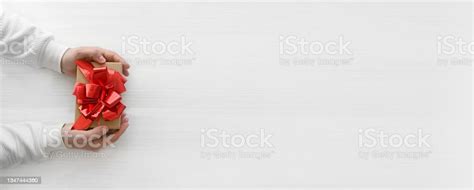 메리 크리스마스와 새해 복 많은 새해 한 남자의 손이 가방에 있는 다른 놀라움 옆에 있는 크래프트 종이에 선물 상자를 들고 있다