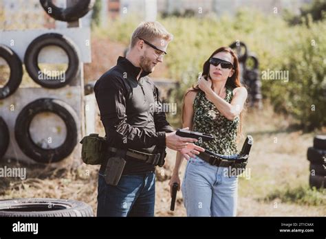 Shooting Instructor Teaching A Woman How To Properly Handle A Weapon At