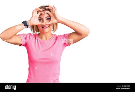 Young Blonde Woman Wearing Sportswear Doing Heart Shape With Hand And Fingers Smiling Looking