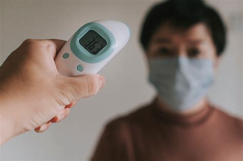 예방 및 보안 측정 예방을 위해 디지털 적외선 온도계를 사용하여 체온 측정 2명에 대한 스톡 사진 및 기타 이미지 2명