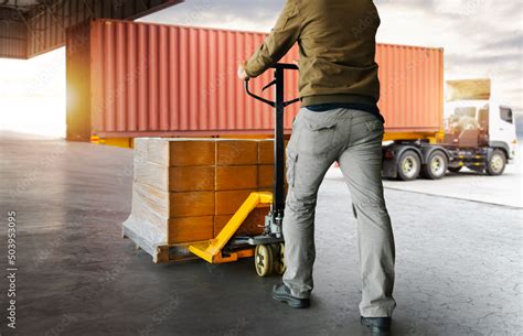 Workers Unloading Packaging Boxes On Pallets To The Cargo Container Trucks Loading Dock