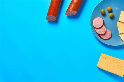 회색 둥근 접시에 슬라이스 치즈 올리브와 소시지는 부엌이나 시장에 파란색 책상에 자리 잡고 있습니다 텍스트의 공백입니다 맨 위 보기 0명에 대한 스톡 사진 및 기타 이미지