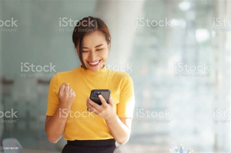 목표를 달성하는 성공적인 젊은 아시아 비즈니스 여성은 사무실에서 노트북을 들고 기뻐하며 손을 들었습니다 새로운 시작 프로젝트