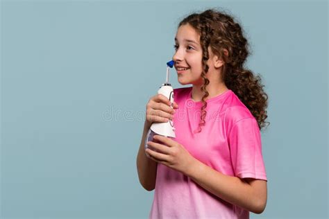 Smiling Young Girl Using An Oral Irrigator Stock Image Image Of Shirt