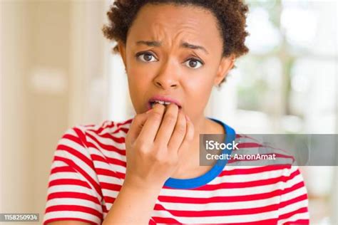 젊은 아름 다운 아프리카 계 미국인 여자 집에서 보고 스트레스와 긴장 으로 손 에 입 물고 손톱 불안 문제 T 셔츠에 대한 스톡