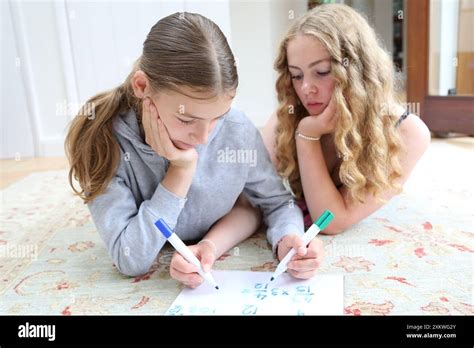 Two Girls Doing Maths Math Lying On Floor Writing On Whiteboard With Pens Fractions Mathematics