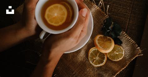 얇게 썬 레몬을 곁들인 접시가 있는 흰색 세라믹 머그잔 사진 Unsplash의 무료 음식 이미지