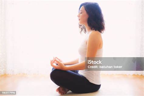 집에서 요가 침착하게 눈을 감고 바닥에 연꽃 위치에 앉아 매력적인 젊은 여성 가정의 방에 대한 스톡 사진 및 기타 이미지