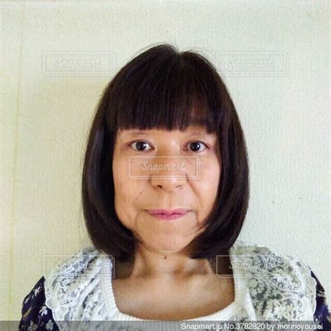 正面を向いて微笑む60歳の女性のポートレートの写真・画像素材 Snapmart（スナップマート）